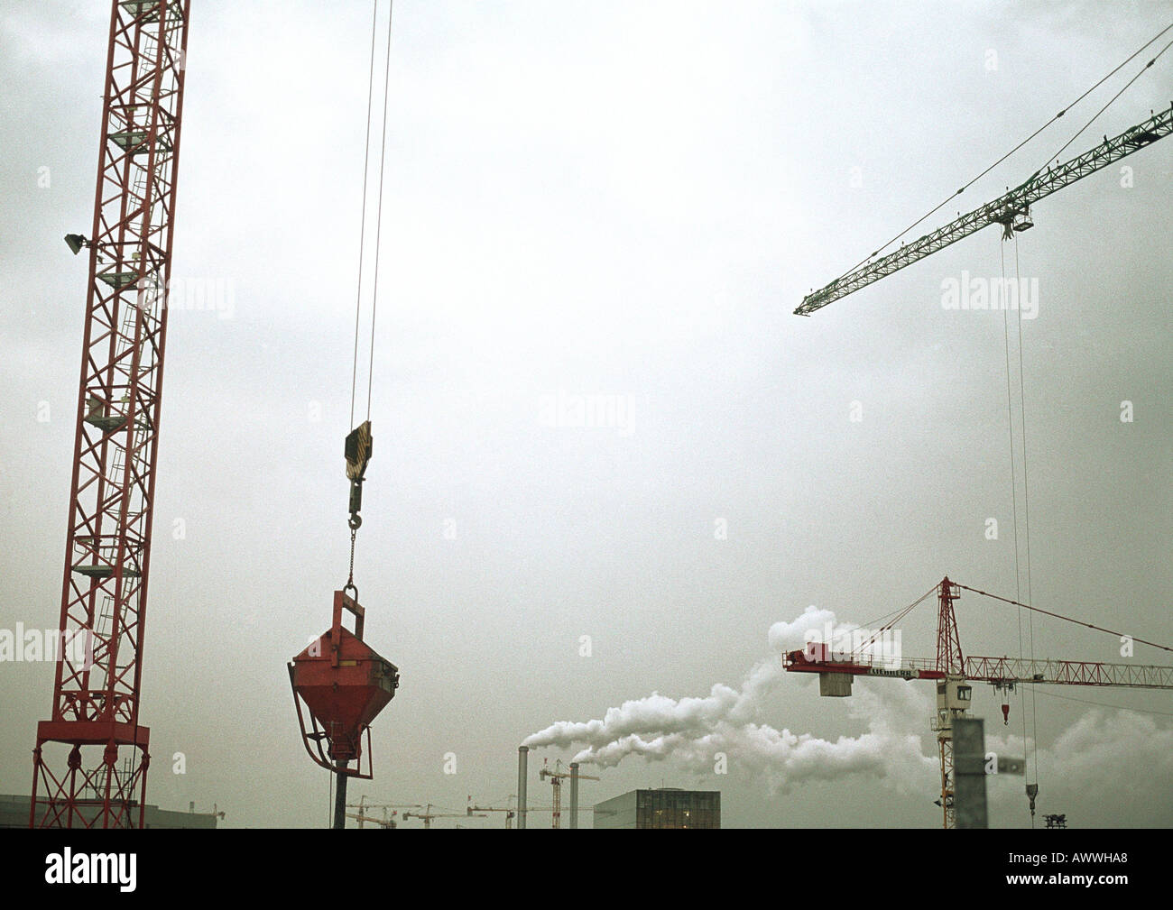 Cranes and factory smoke stacks, low angle view Stock Photo - Alamy