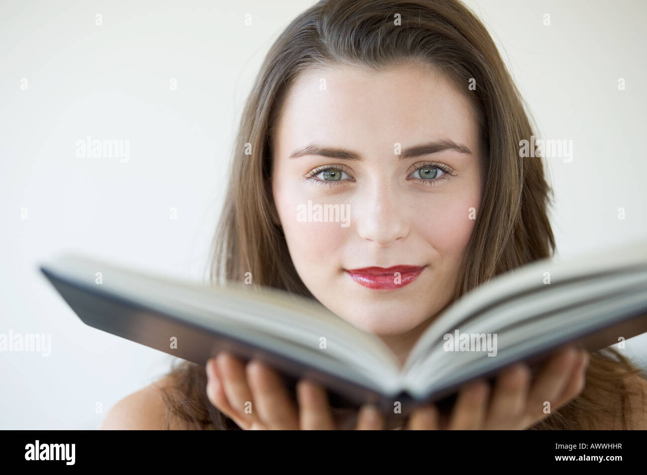 Young woman holding a book open in her hands Stock Photo - Alamy