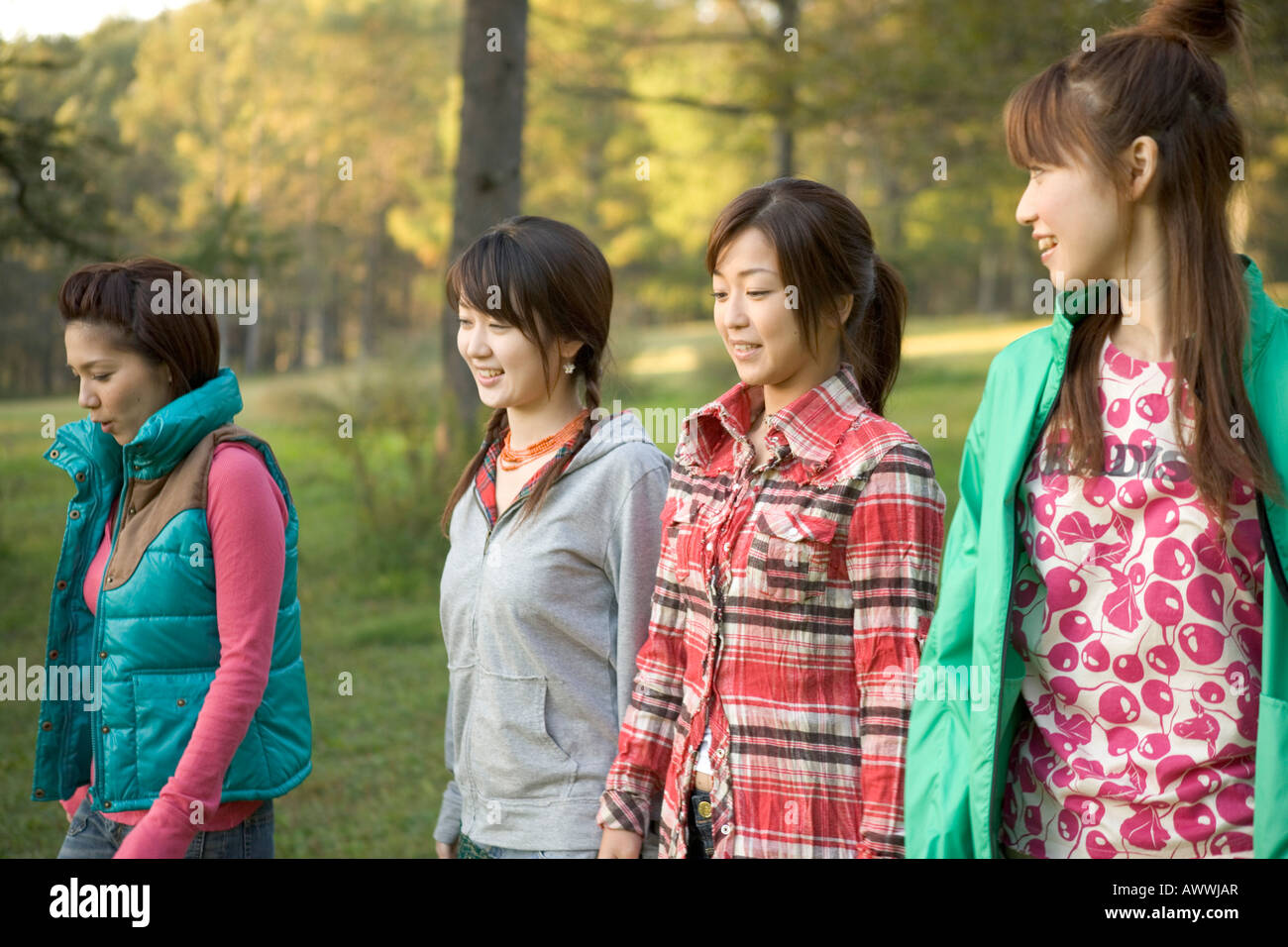 Four teenage girls walking side by side in forest Stock Photo - Alamy