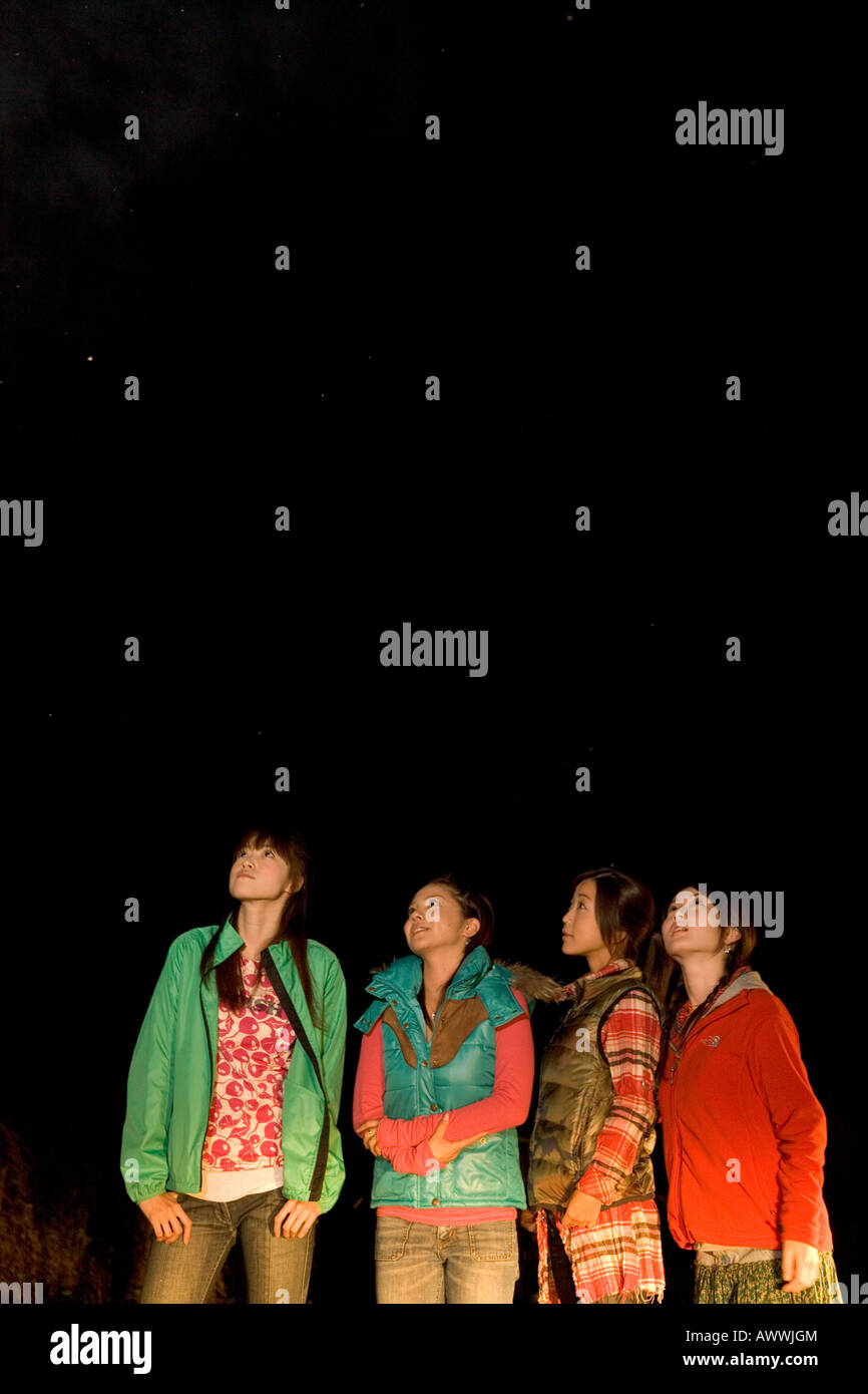 Four young women relaxing outdoors Stock Photo - Alamy