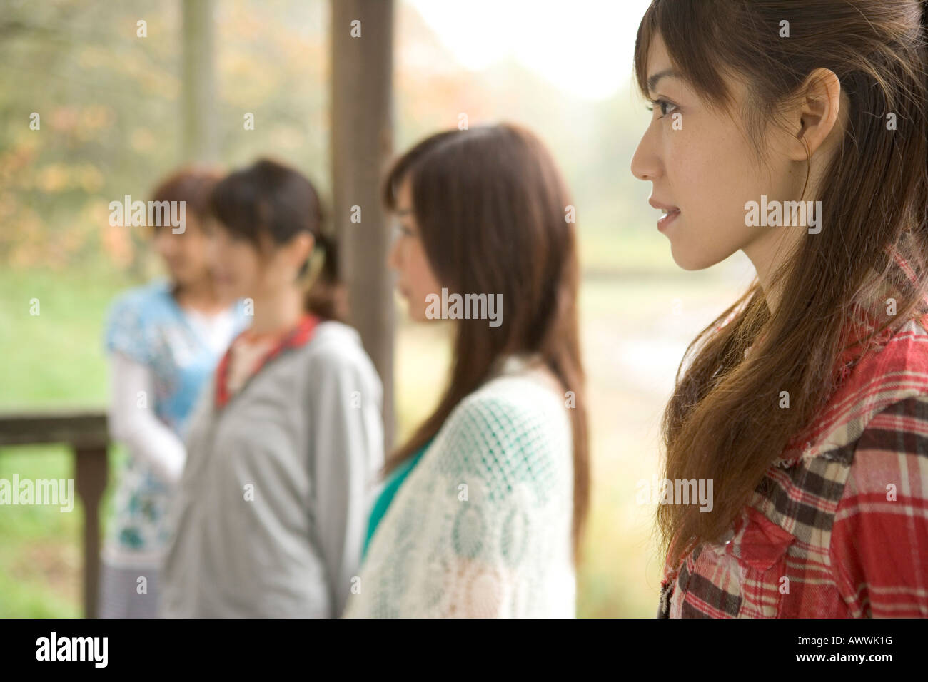 Four young women standing in row on porch Stock Photo - Alamy