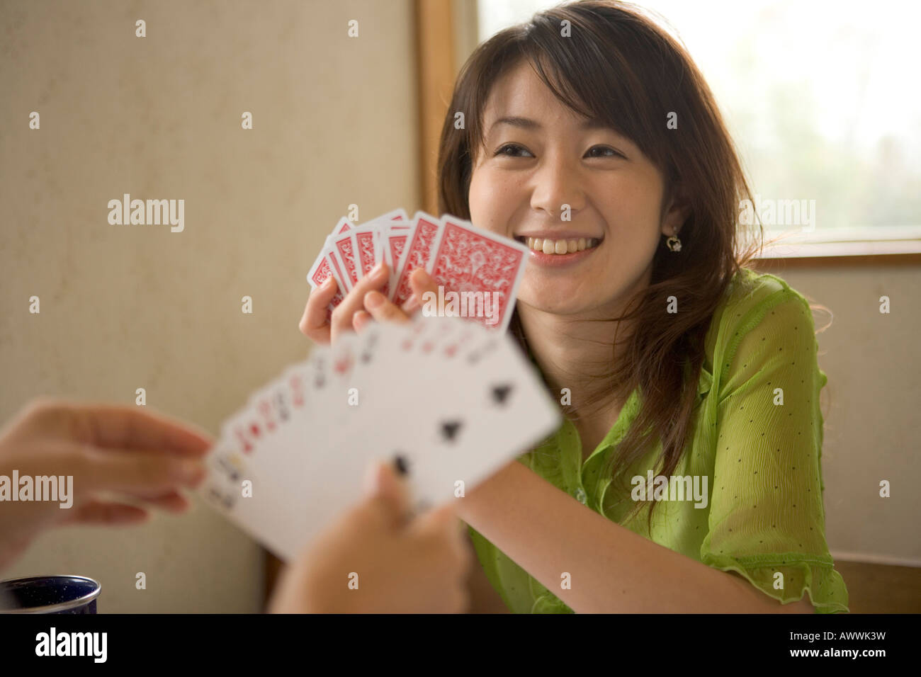 Young women playing cards Stock Photo - Alamy