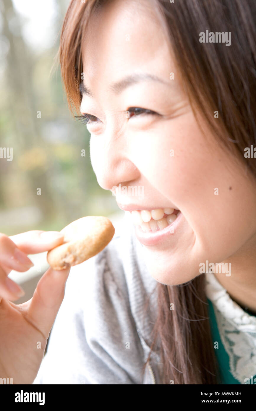 Young woman eating cookie Stock Photo - Alamy
