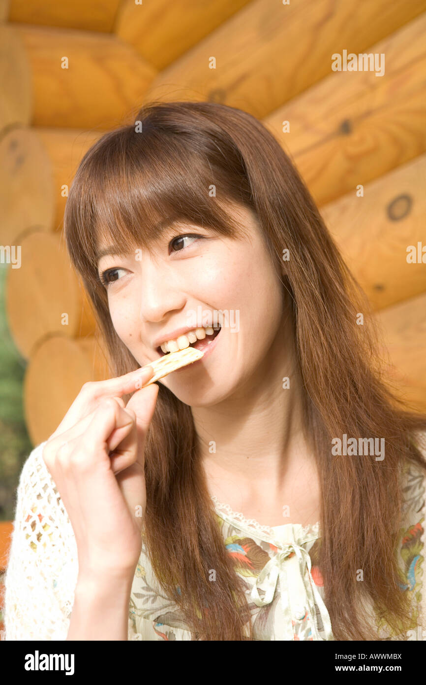 Young woman eating snack Stock Photo - Alamy