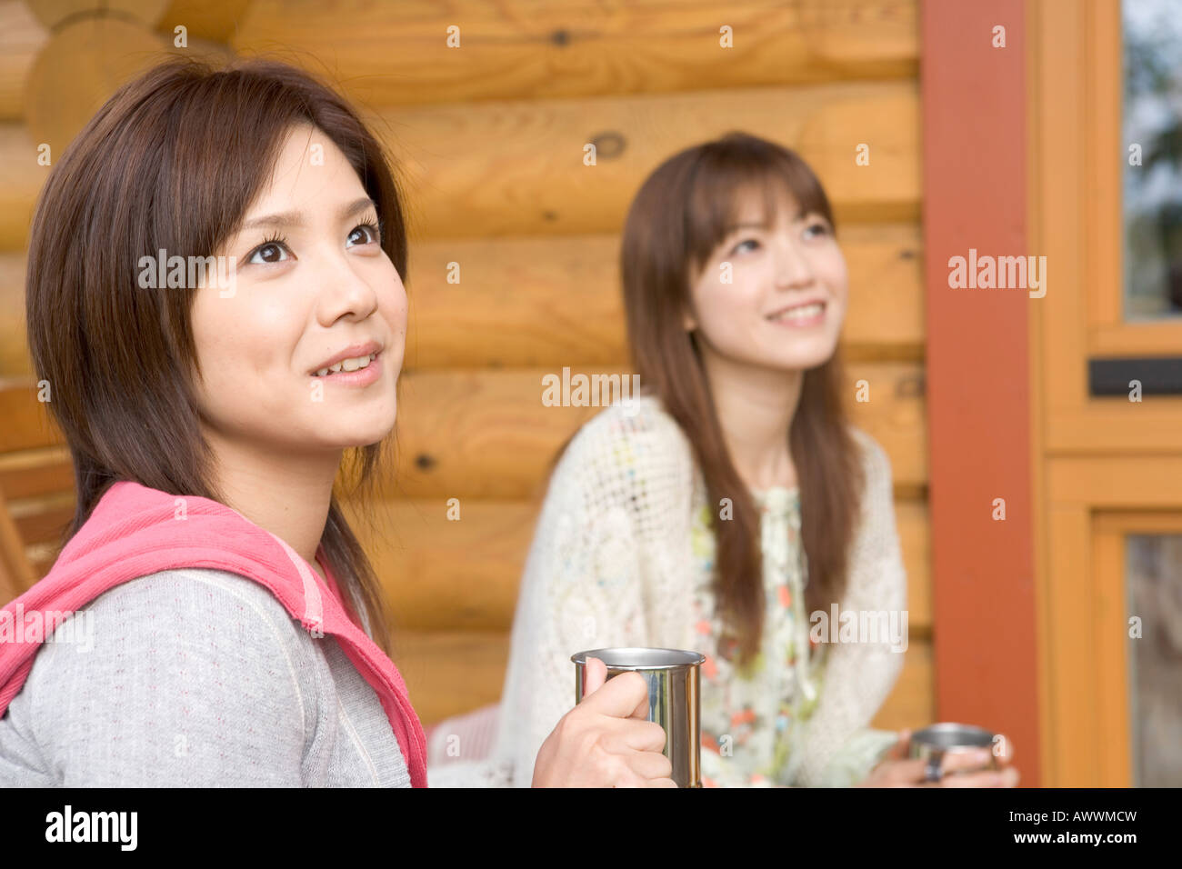 Two young women relaxing on porch Stock Photo - Alamy