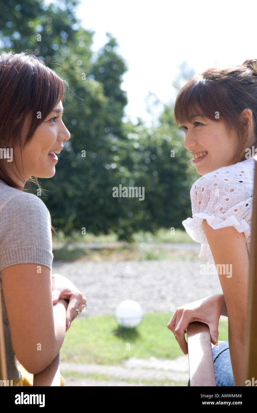 Two young women talking outdoors Stock Photo - Alamy