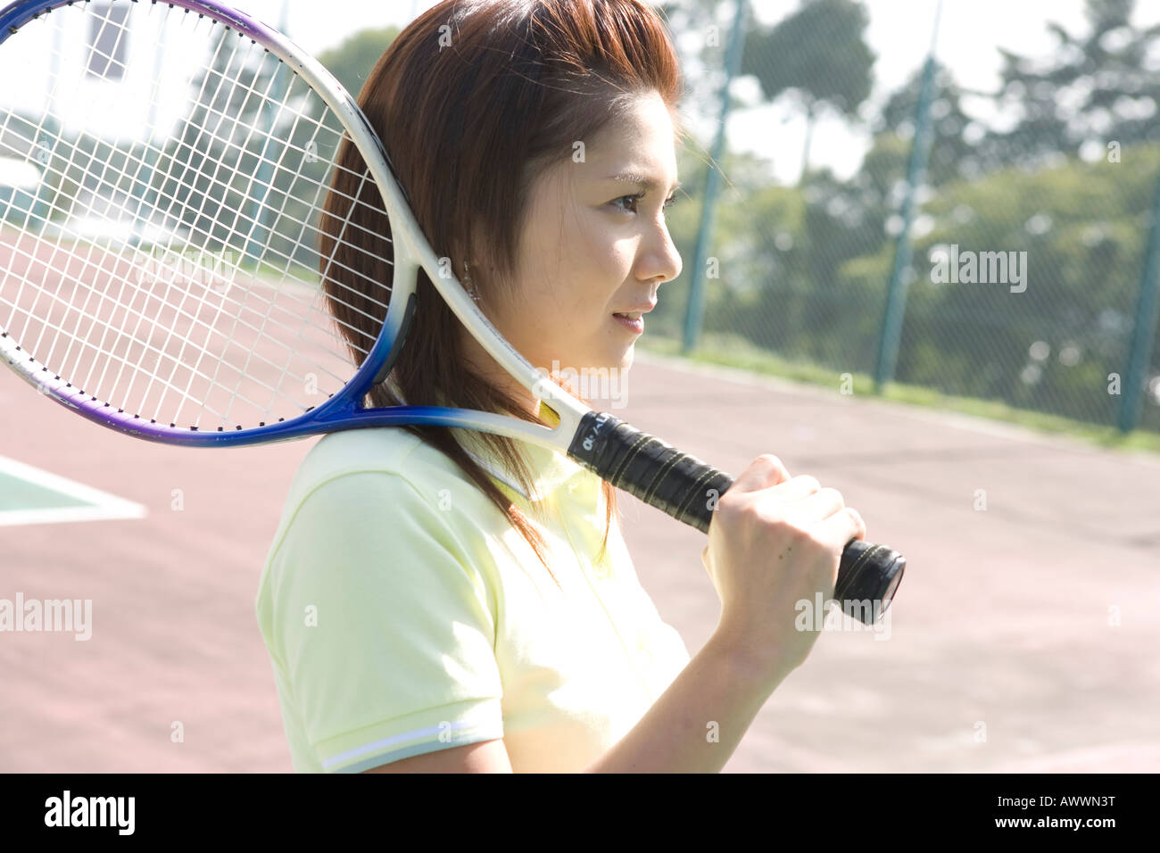 Teenage girl holding tennis racket, side view Stock Photo - Alamy