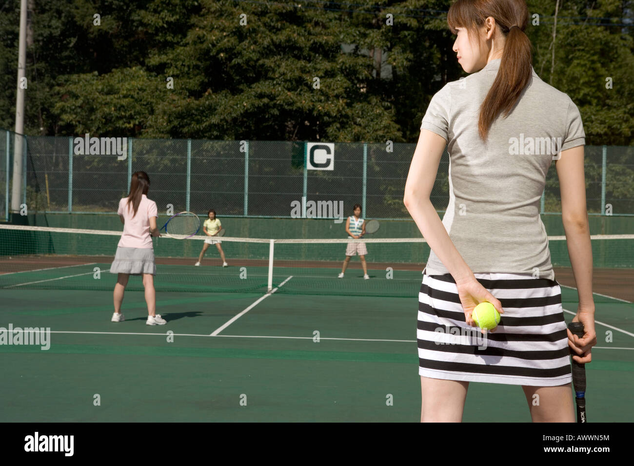 Young women playing tennis on outdoor court Stock Photo - Alamy