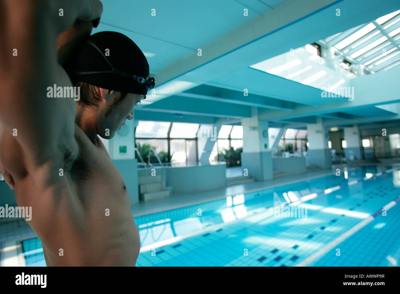 Swimmer stretching standing on edge of swimming pool Stock Photo - Alamy