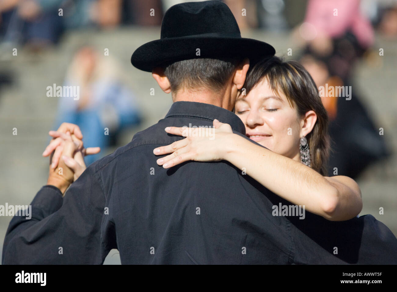 Spanish woman closes eyes and smiles as she holds her partner as they ...