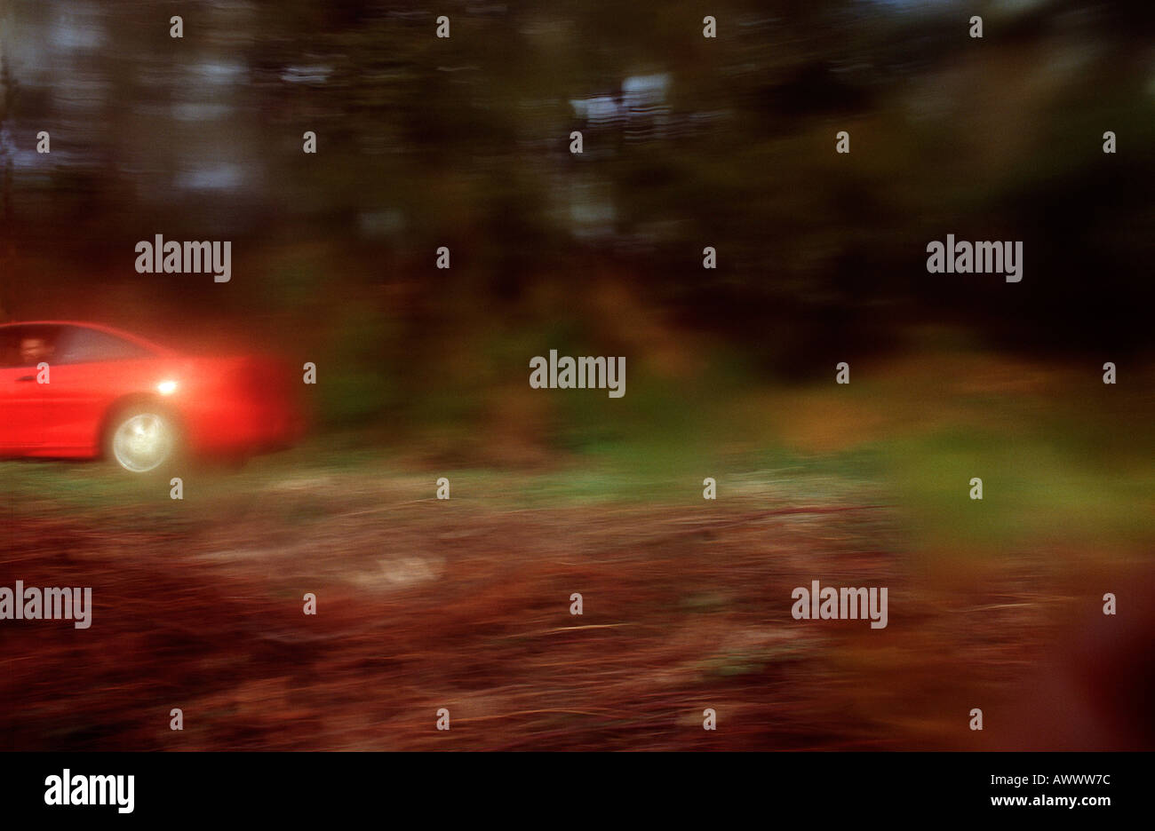 moving red car automobile streaks through country side Stock Photo - Alamy