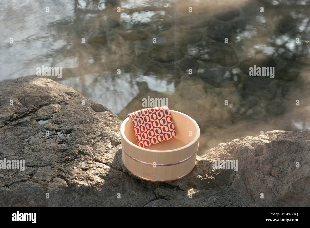 Wooden bucket on rock in japanese spa Stock Photo - Alamy