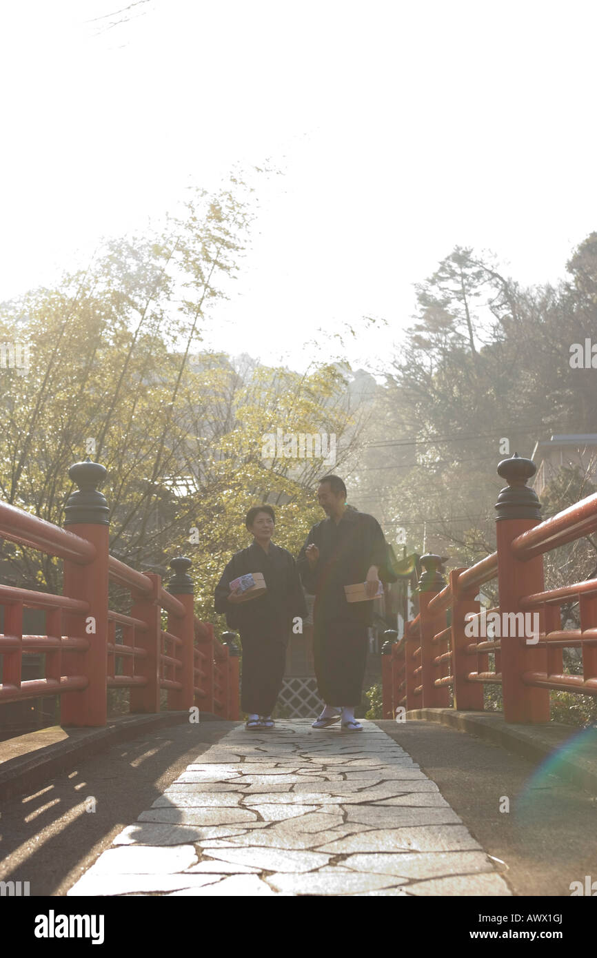 Elderly couple walking over bridge, holding buckets, smiling Stock ...