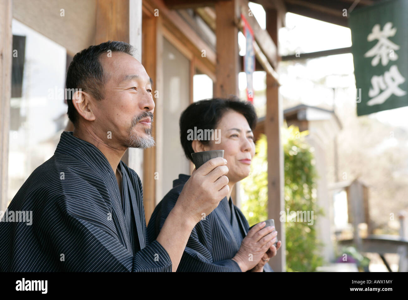 Elderly couple sitting in front of house, drinking tea Stock Photo - Alamy