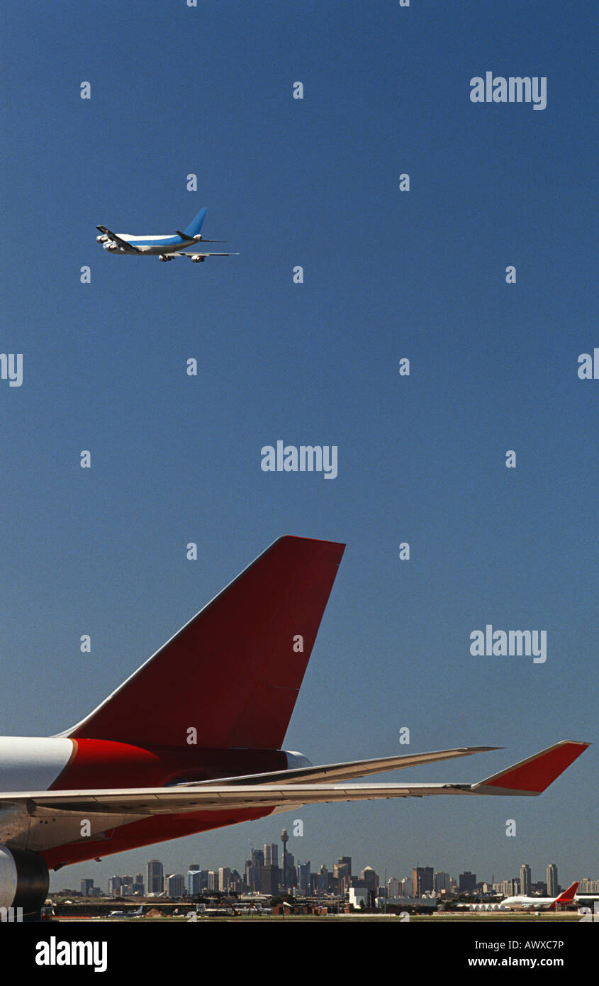 Close-up of airplane's tail fin, flying plane in background Stock Photo ...