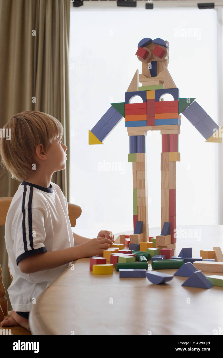 Boy (5-6) playing with building blocks at table Stock Photo - Alamy
