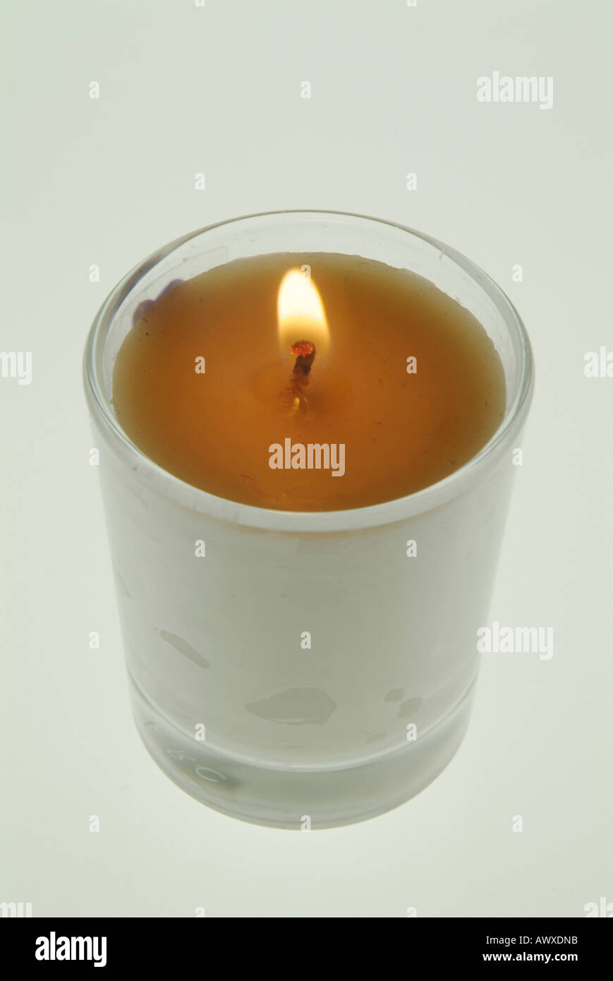 Burning candle in glass container Stock Photo - Alamy
