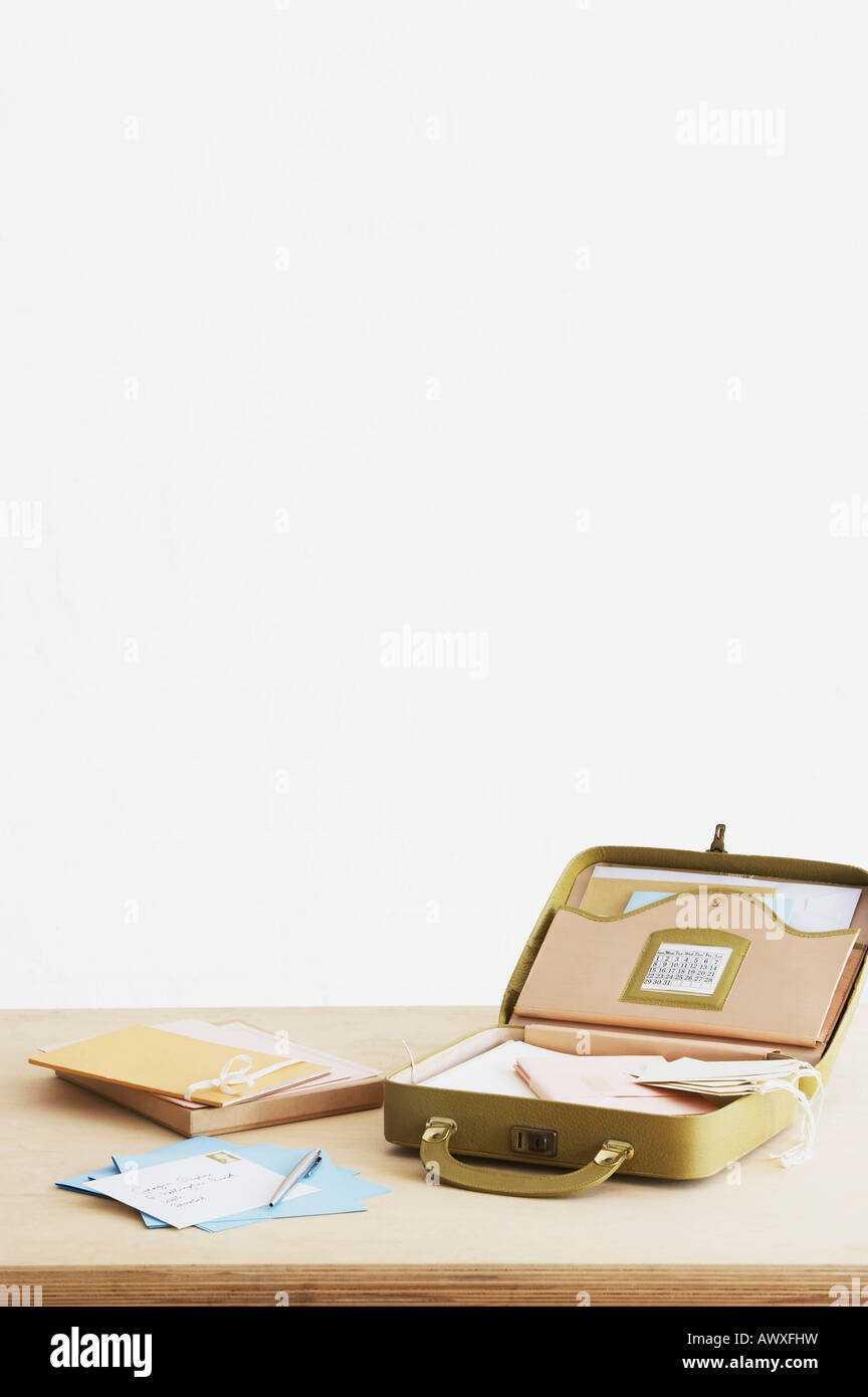 Postcard and envelopes next to suitcase with stationery items, elevated ...