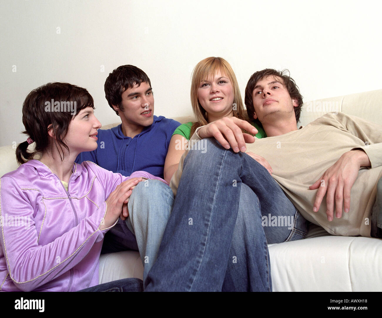four teenagers together on a sofa Stock Photo - Alamy