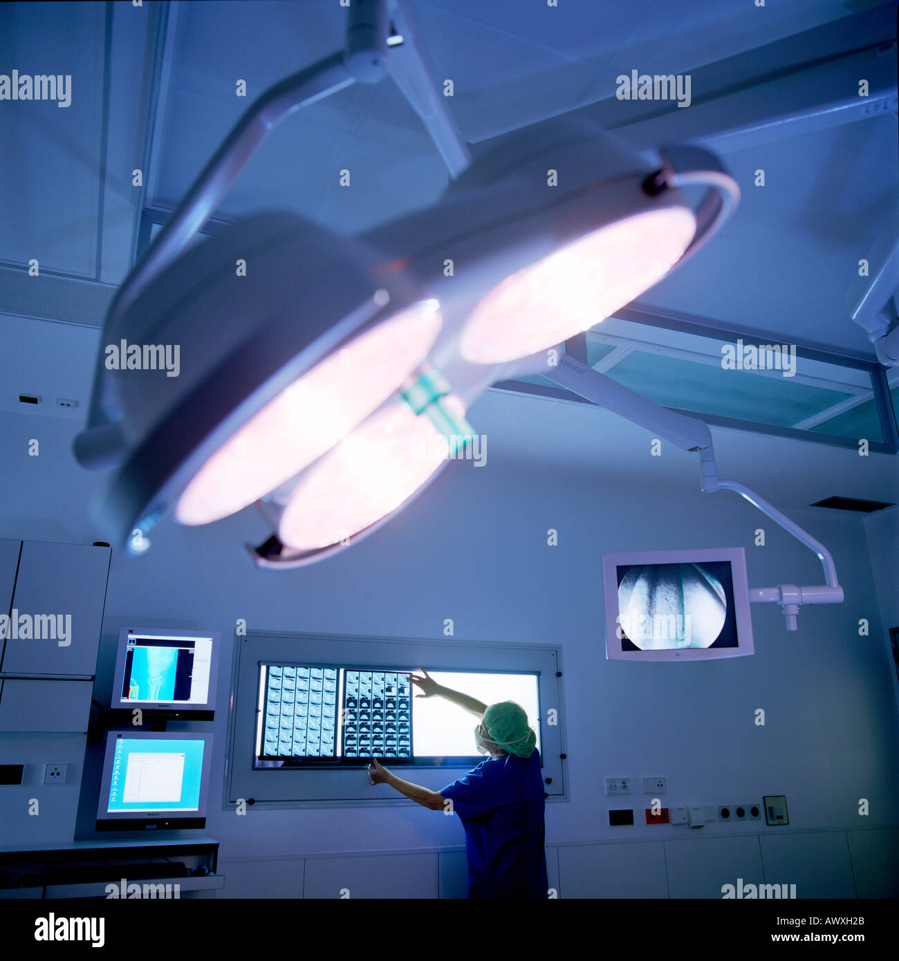 surgeon checking x rays in hospital operating theatre surgery lights in ...