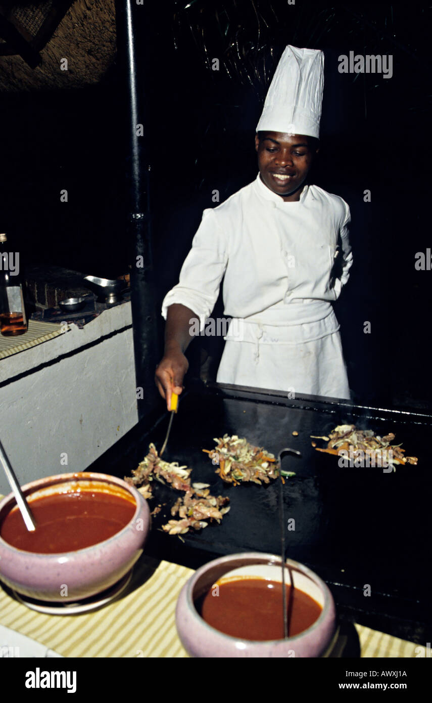Chef cooking local game meat on a metal plate Victoria Falls Hotel ...