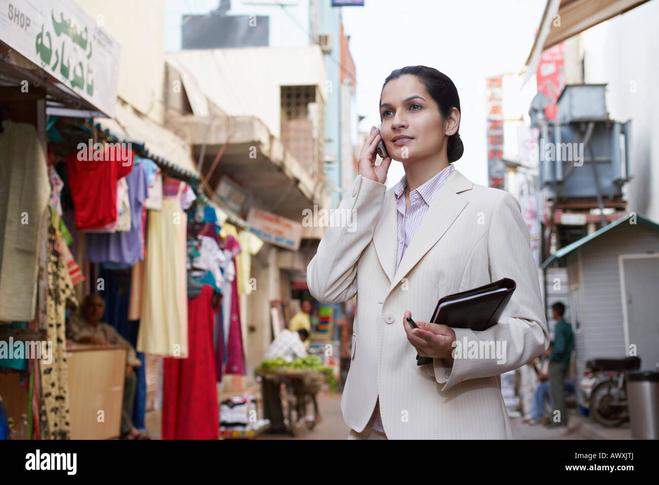 Business woman using cell phone on bazaar Stock Photo - Alamy