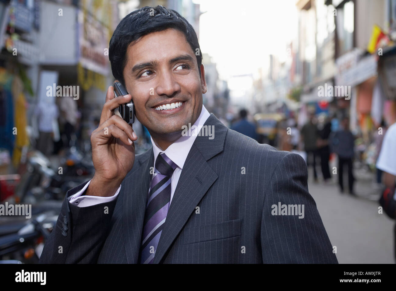 Business man using cell phone on city street, smiling Stock Photo - Alamy