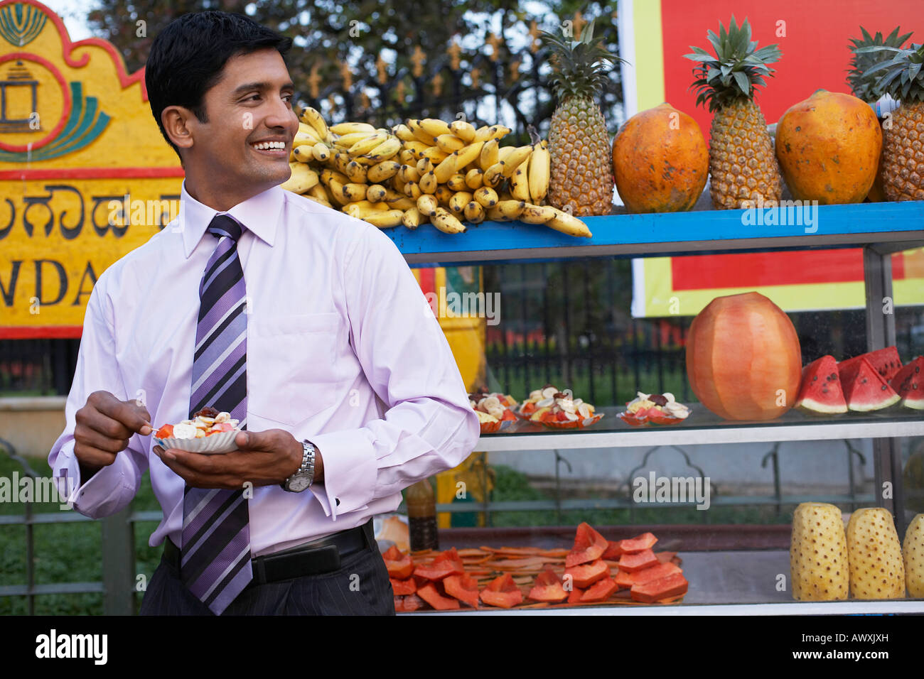 Businessman standing in front of fruit stall Stock Photo - Alamy