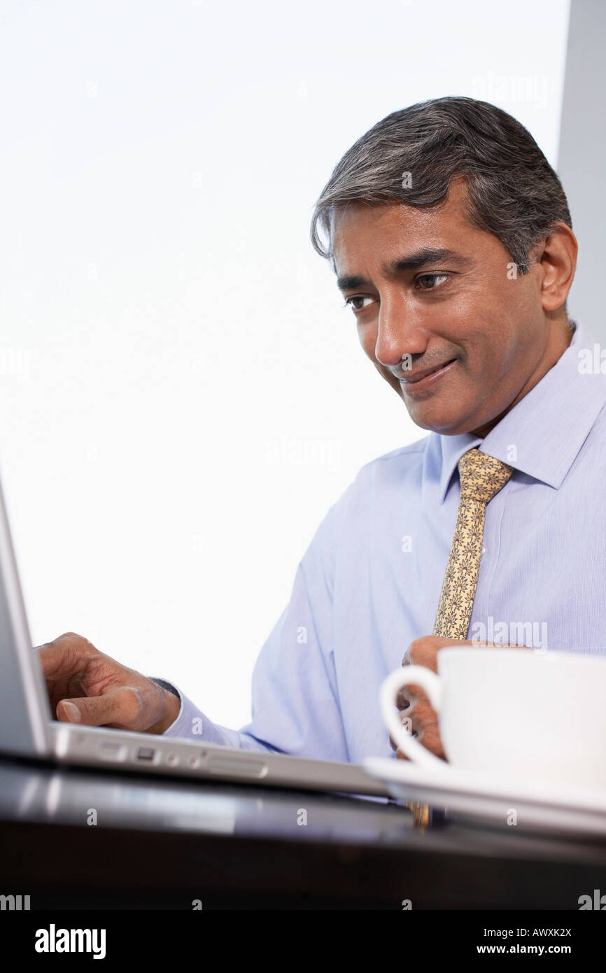 Business man using laptop, smiling, low angle view Stock Photo - Alamy