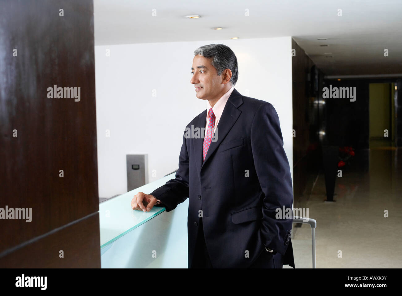 Business man standing by counter Stock Photo - Alamy