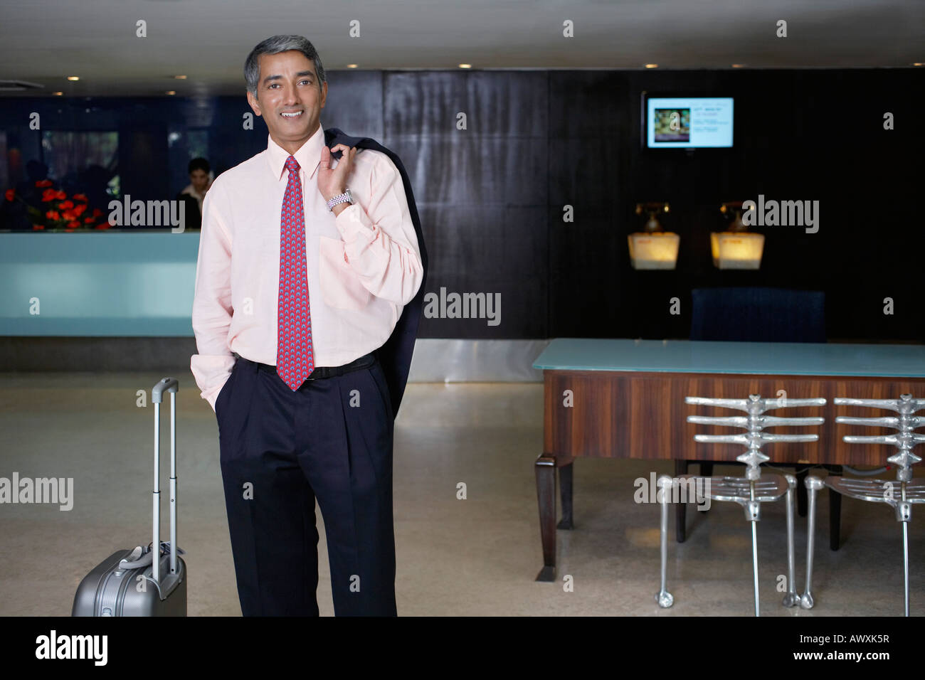 Business man standing in hotel lobby, portrait Stock Photo - Alamy