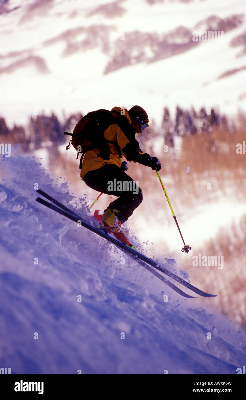 An extreme skier makes his turn in the air to get his skis out of the ...