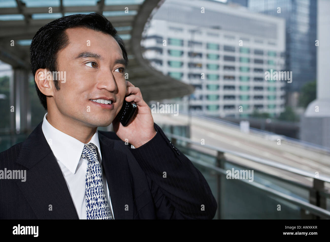 China, Hong Kong, business man using mobile phone, standing on ...