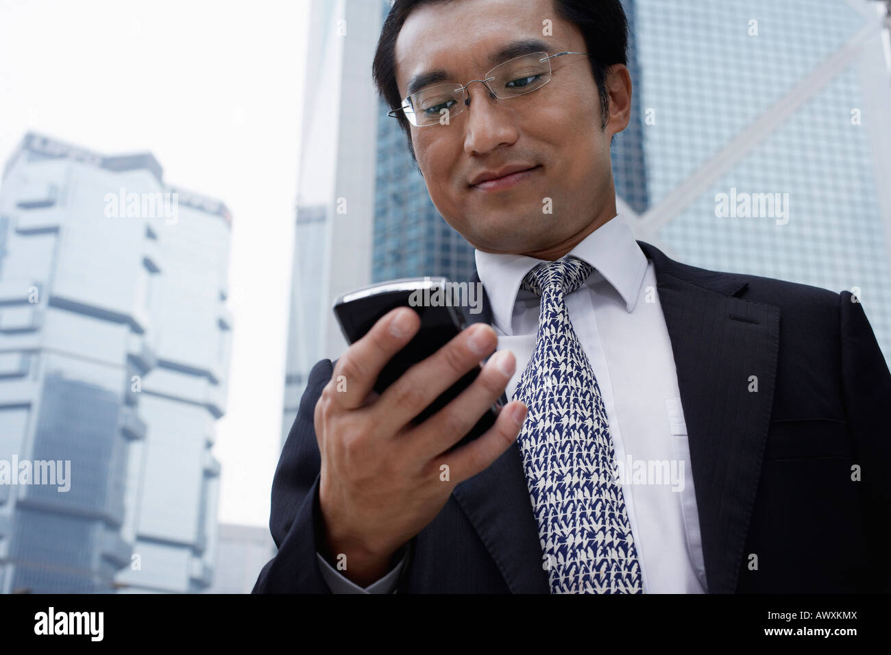 China, Hong Kong, business man text messaging standing in business ...