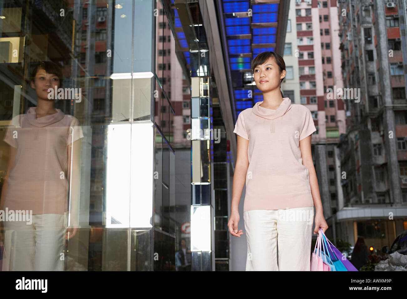 Woman walking past store, looking at window display Stock Photo - Alamy