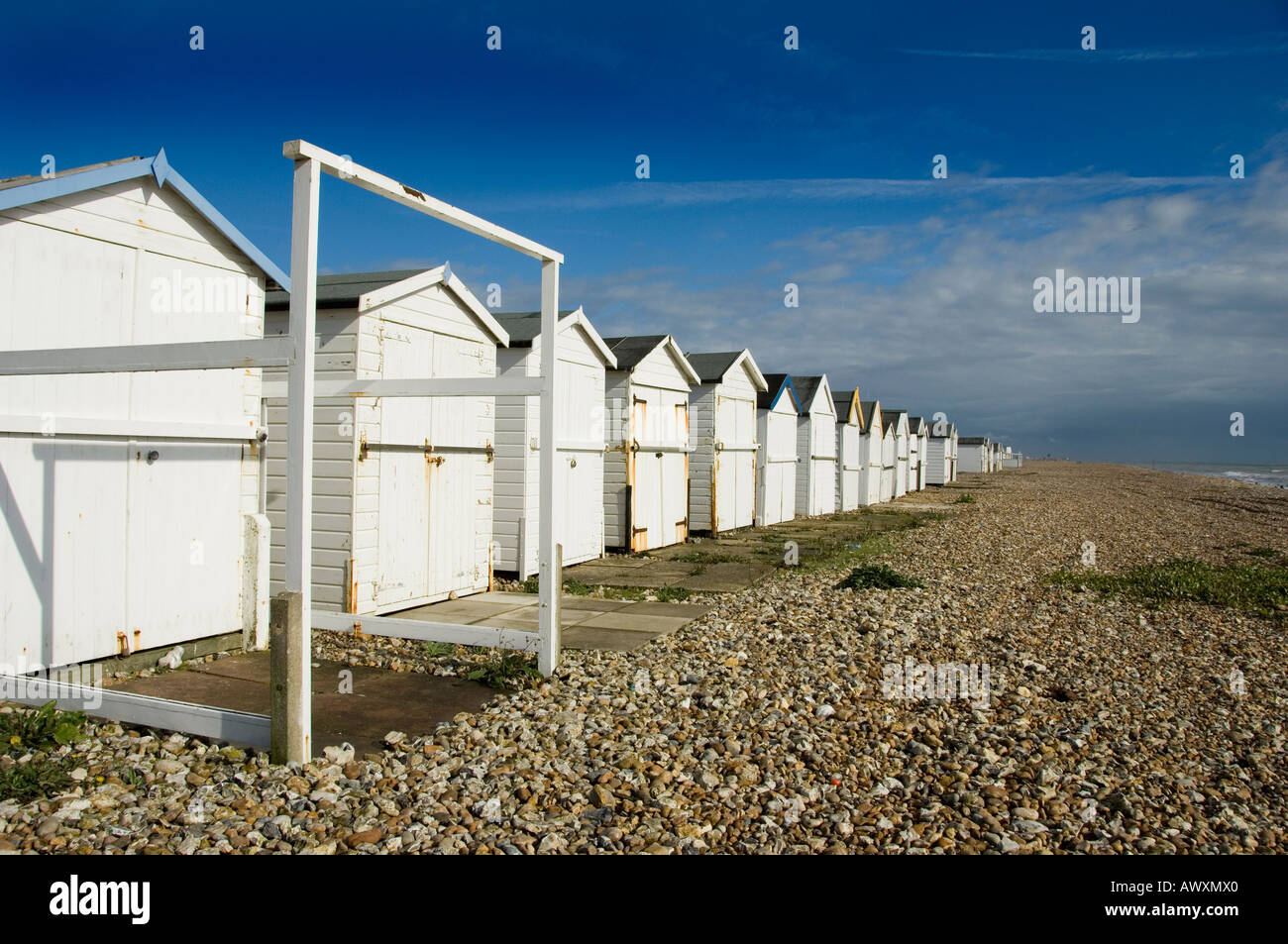 left side view of beach huts with the blue sky and pebble beach in the ...