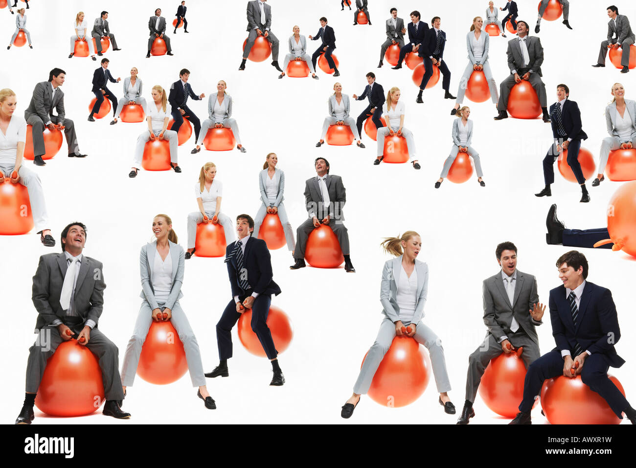 Large group of business people bouncing on inflatable balls, studio ...