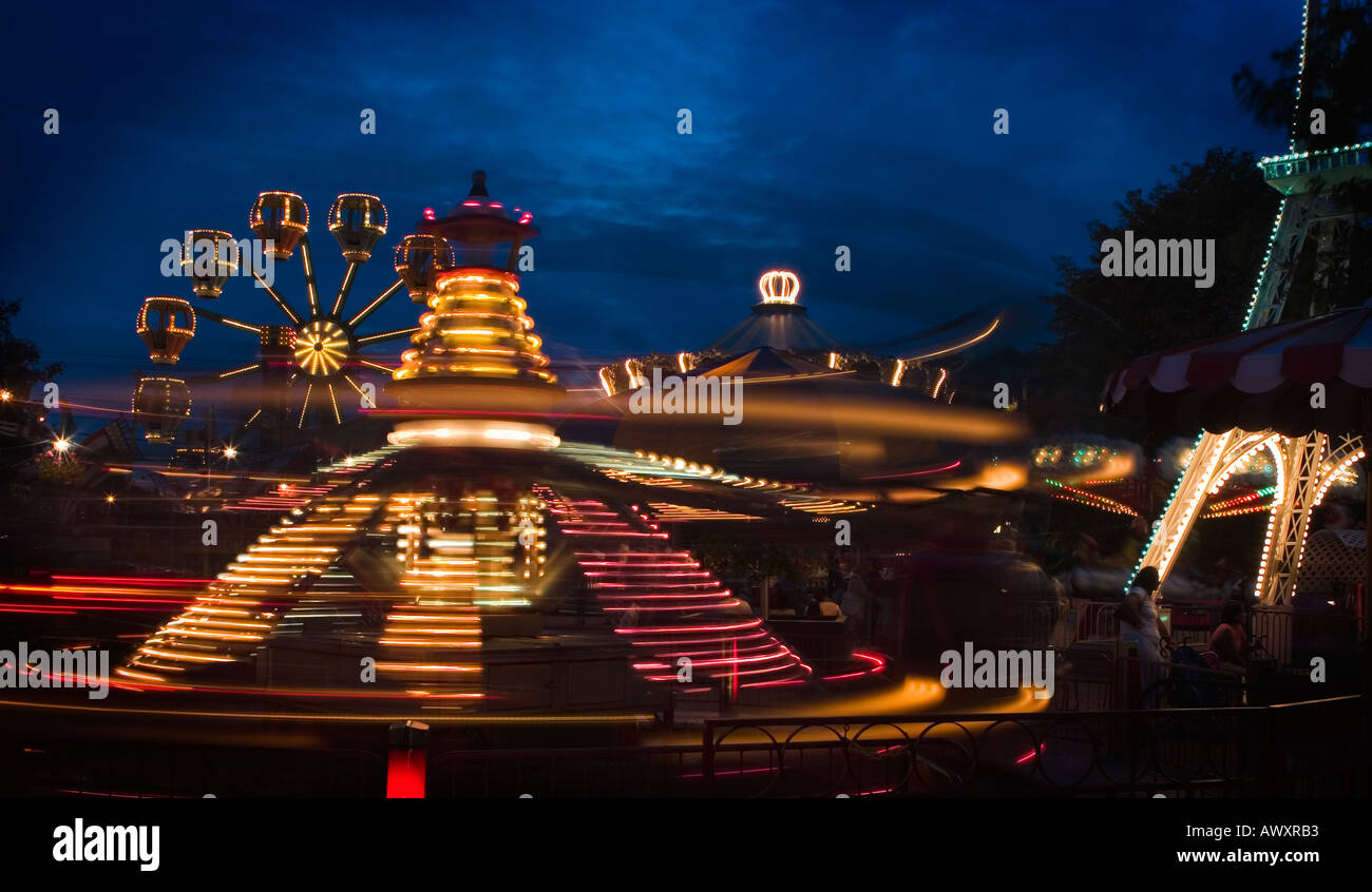 spinning rides at an amusement park at nighttime all with motion blur ...