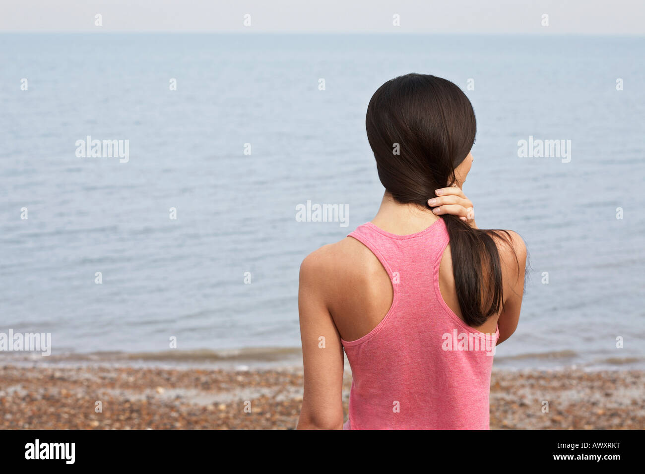 Young woman standing on beach, back view Stock Photo - Alamy