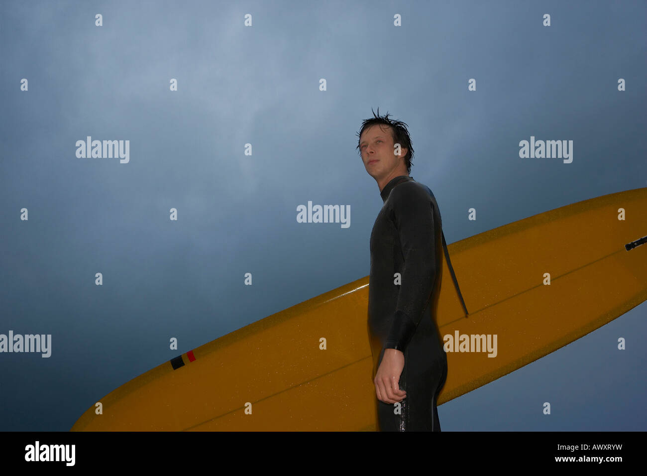 Surfer carrying surfboard on beach, side view, low angle view Stock ...