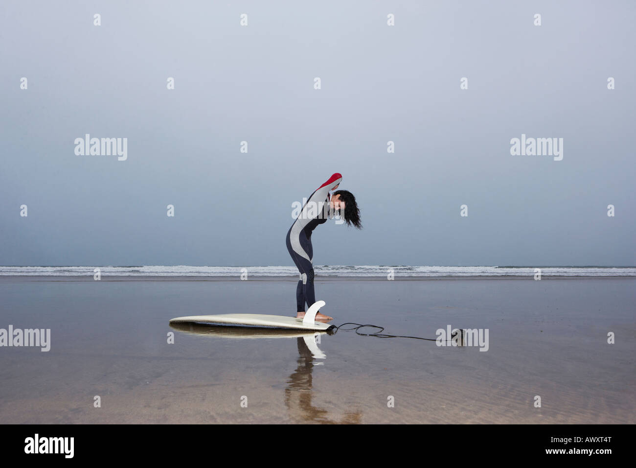 Female surfer standing in shallow water, side view Stock Photo - Alamy
