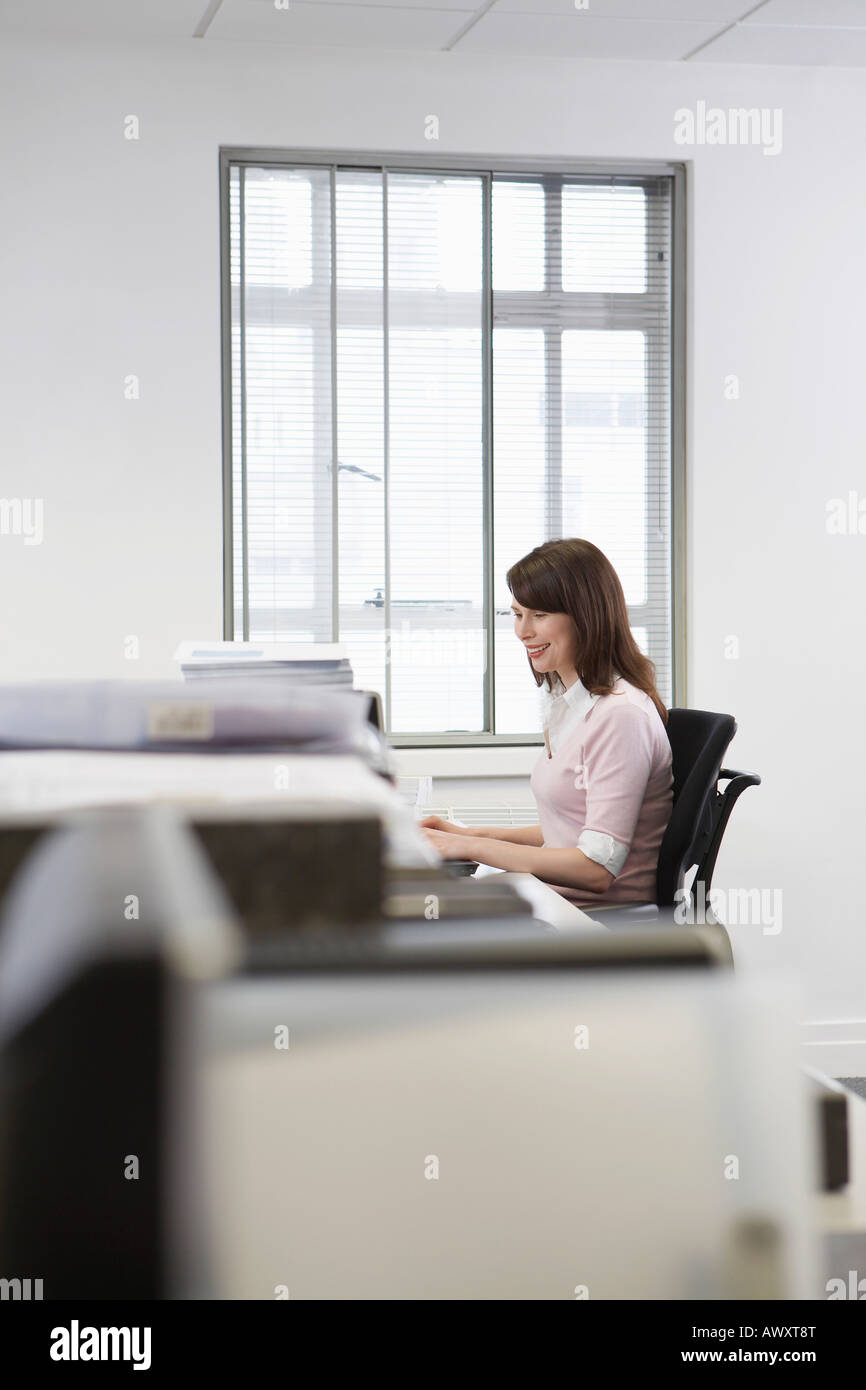 Woman working at desk in office, side view Stock Photo - Alamy