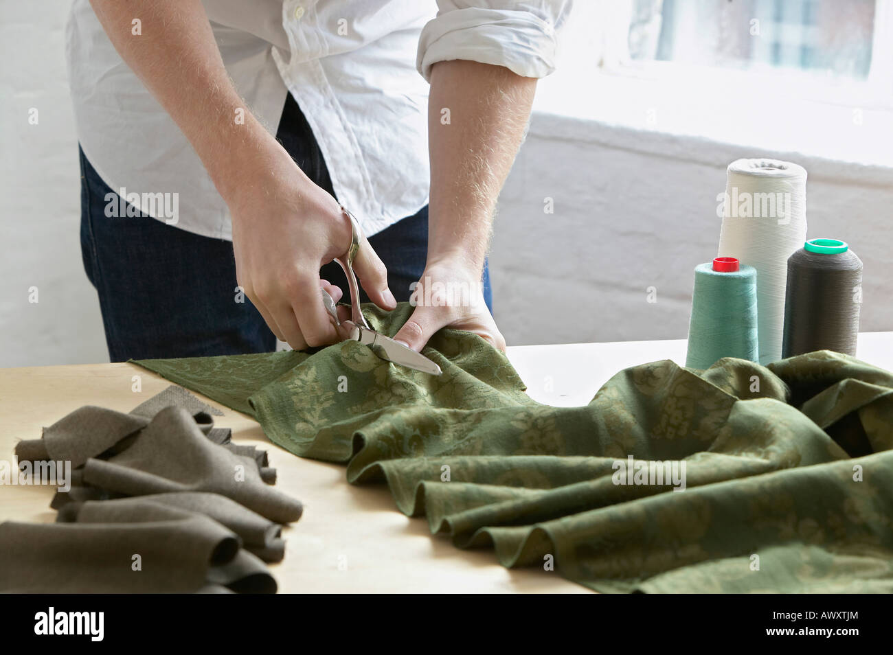 Tailor cutting fabric, mid section, close up Stock Photo - Alamy