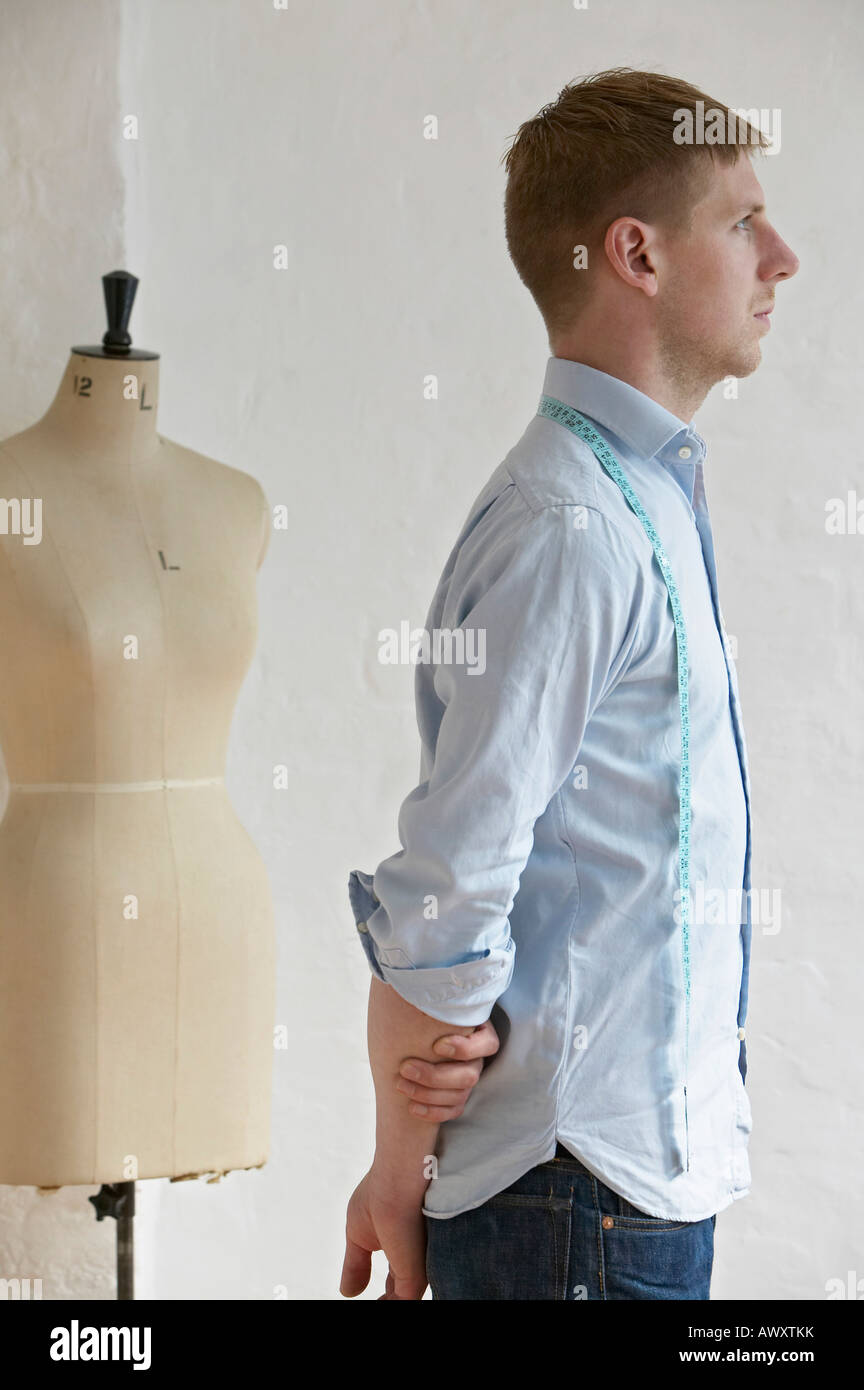 Tailor standing next to mannequin, side view Stock Photo - Alamy