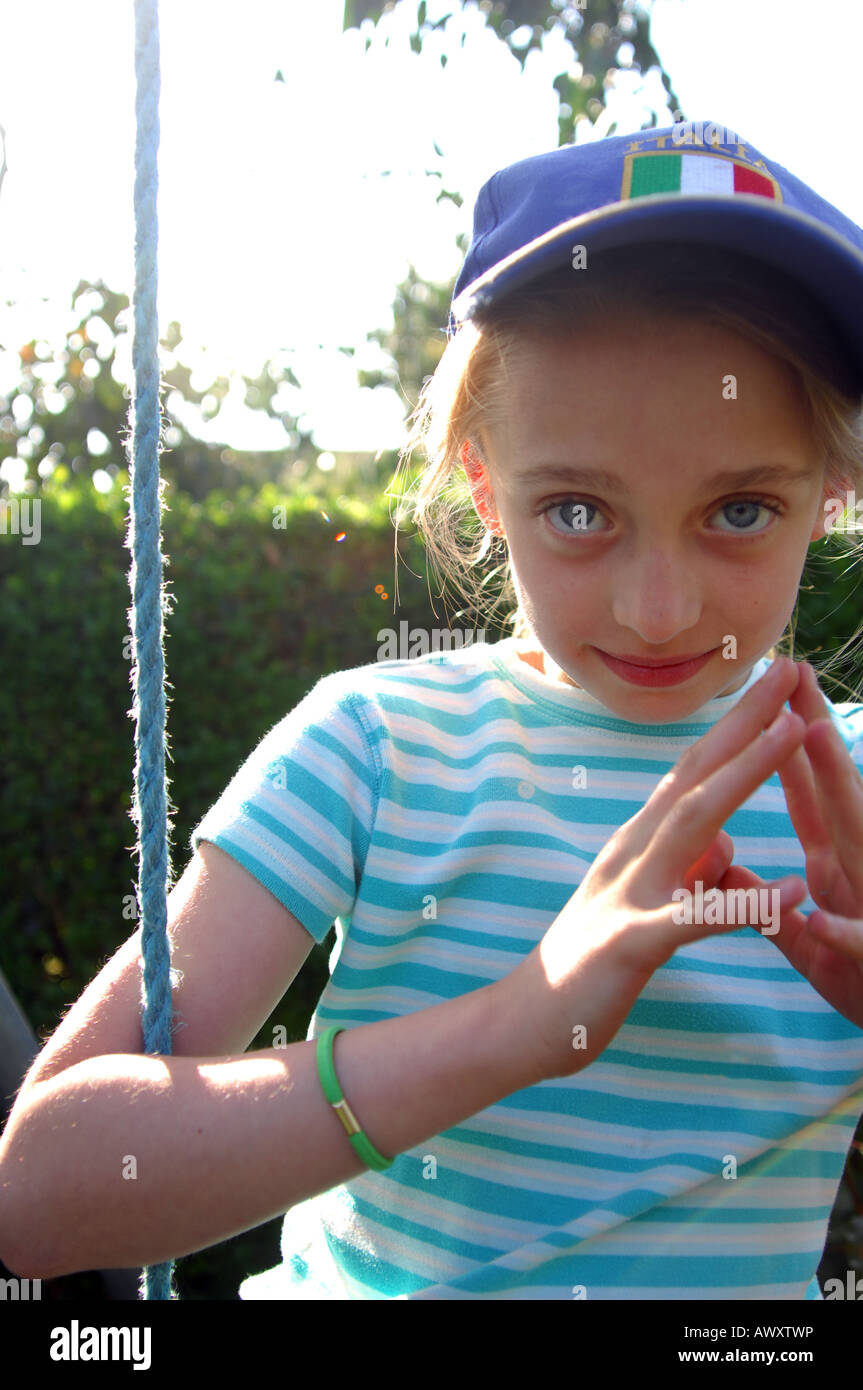 Photograph of young girl posing in the sunshine with baseball hat on ...