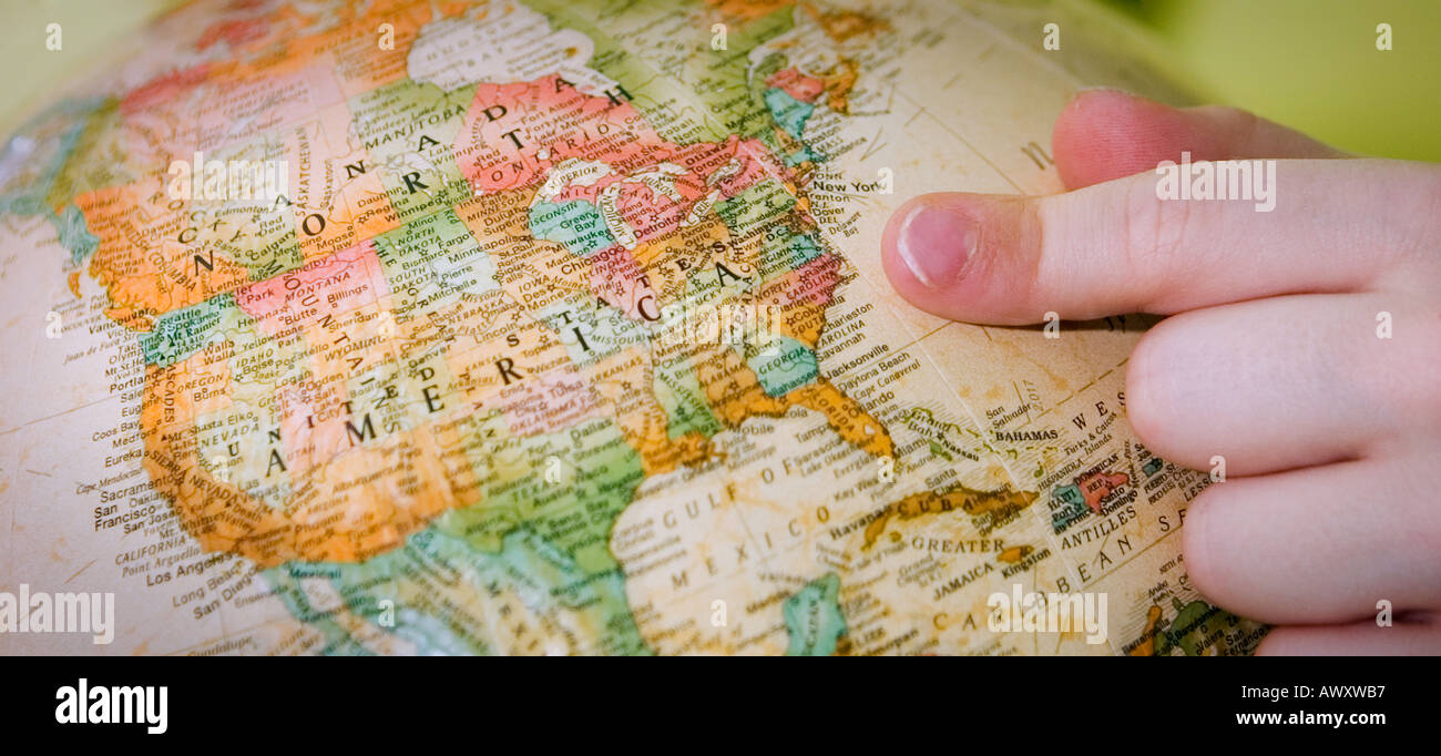 childs hand and finger pointing to the United States of America on a ...