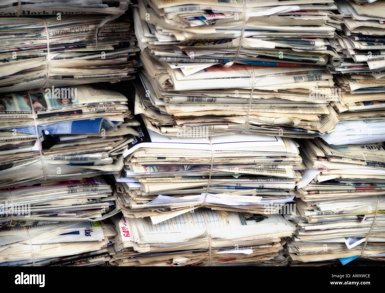 piles of newspapers bundled up with twine sitting at the curb waiting ...