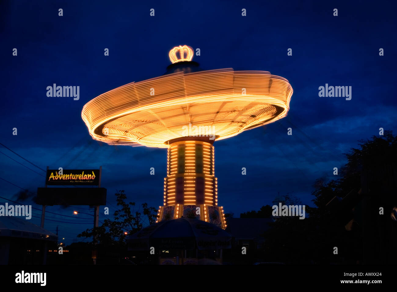 spinning swing amusement park ride lit up at night with deep rich blue ...