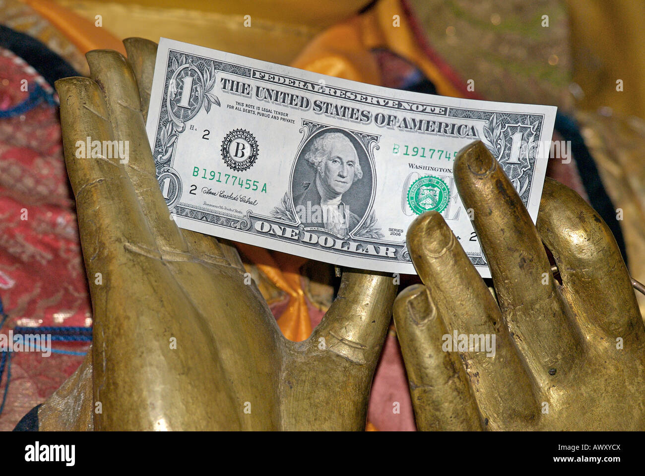 Detaill of a one dollar banknote in the hands of a buddhist statue at ...