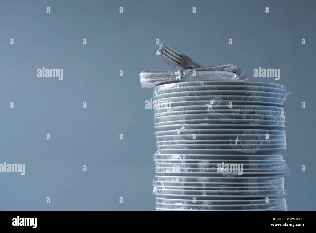 Stack of plates and cutlery wrapped in plastic Stock Photo - Alamy